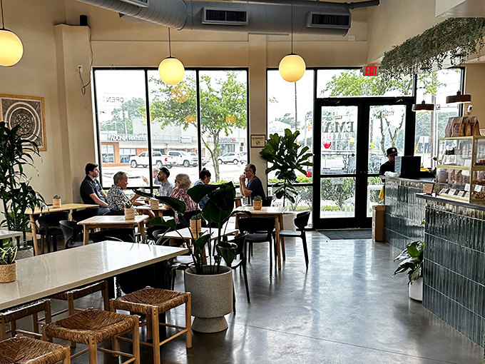 Light floods through windows illuminating wooden tables where culinary memories are made. Plants stand guard over happy diners.