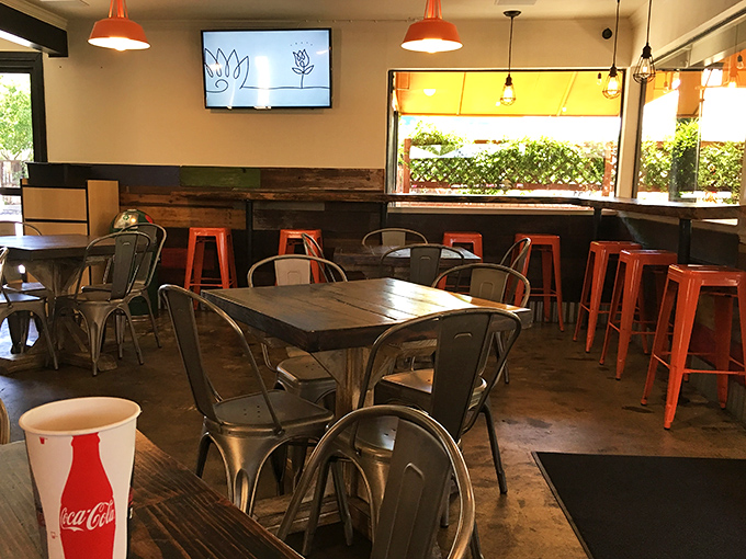 Orange accents pop against industrial elements, creating a space that's both welcoming and Instagram-worthy without trying too hard.