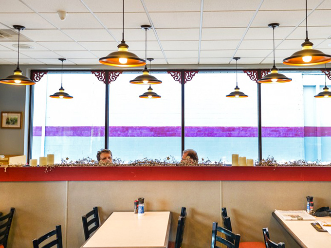 The warm, inviting interior features pendant lighting and comfortable seating. A temple of carbohydrate worship where conversations flow as freely as the caramel.