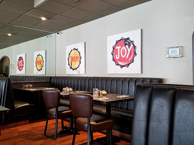 Colorful bottle cap art declaring "DREAM" and "JOY" watches over diners from leather booths. Sometimes restaurant decor just gets straight to the point.