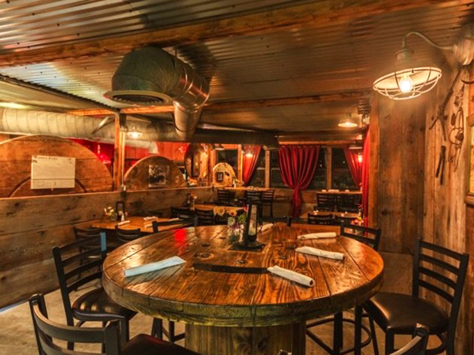 Rustic elegance defined: wooden tables worn smooth by decades of elbows and stories, bathed in the warm glow that makes everyone look like they're in a food commercial.