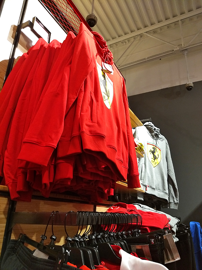 Ferrari red hoodies hang like trophies, offering a taste of Italian luxury at a fraction of the sports car's sticker price.