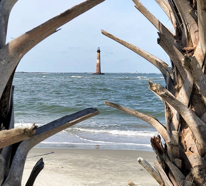The lighthouse stands tall against a crystal blue sky, looking like it's auditioning for a coastal lifestyle magazine cover.