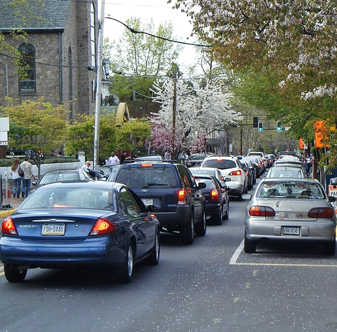 Spring blossoms frame New Hope's bustling main street, where cars line up for a taste of small-town magic during peak season.