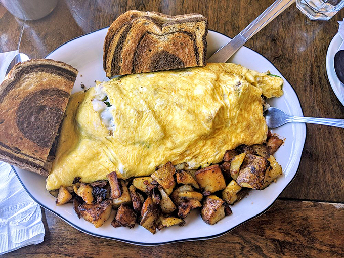 This omelet doesn't just sit on the plate&mdash;it lounges confidently, knowing it's the Beyonc&eacute; of breakfast. Surrounded by perfectly roasted potatoes and marble rye toast.