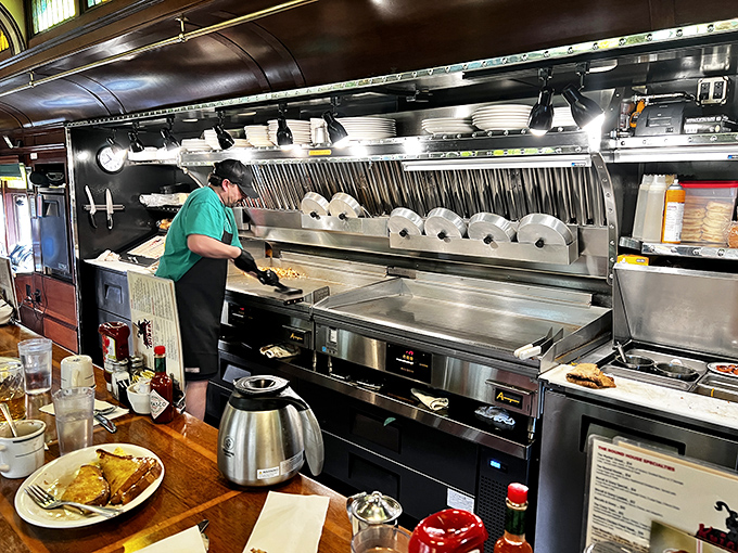 The open kitchen reveals the choreography behind the comfort&mdash;stainless steel, practiced hands, and the satisfying sizzle of breakfast in the making.