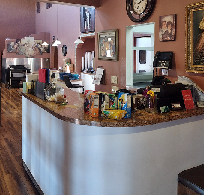 The front counter tells stories without words&mdash;family photos, religious art, and the quiet efficiency of a restaurant that knows its purpose.