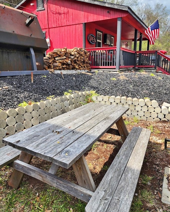 Rustic picnic tables outside the red barn offer a perfect stage for the messy, wonderful performance that is eating great barbecue.