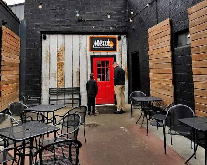 The red door entrance feels like the gateway to a meat-lover's Narnia. Black walls and wooden accents create the perfect barbecue aesthetic.