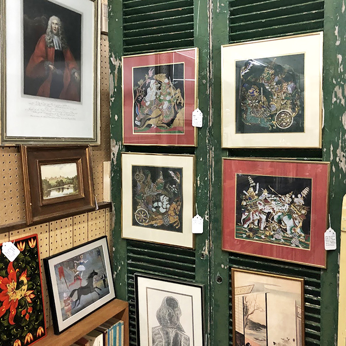 Framed artwork covers every inch of wall space, creating an impromptu gallery of forgotten masterpieces.
