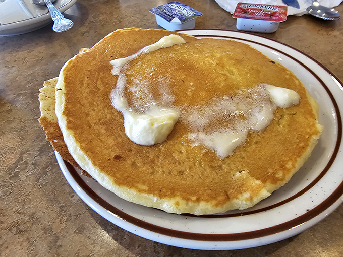 This pancake isn't just large&mdash;it's practically a circular mattress of fluffy goodness, melting butter creating little pools of heaven that no maple syrup could resist. 