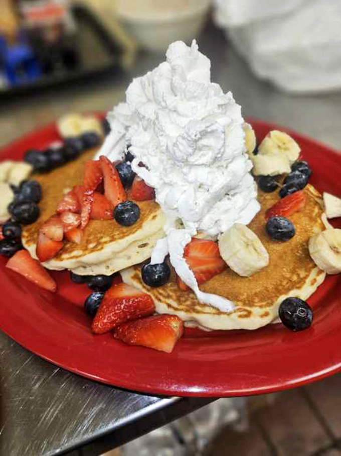 Pancakes wearing their finest fruit jewelry and a whipped cream hat. This stack isn't breakfast&mdash;it's an event your fork has been training for.