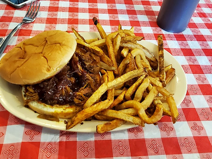 The pulled pork sandwich on a classic red-checkered tablecloth&mdash;where the sauce-soaked meat and hand-cut fries make you forget about your phone for once.