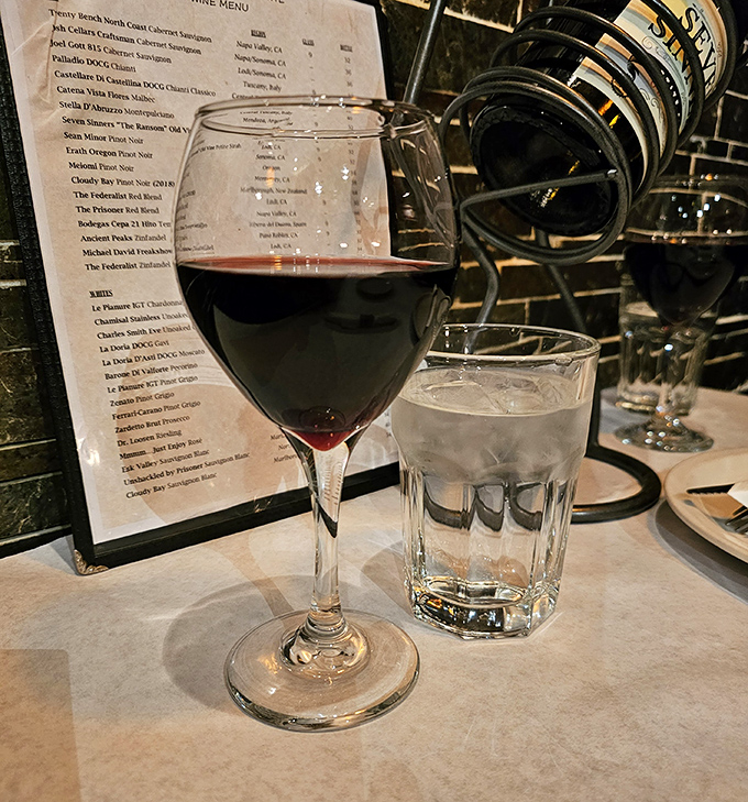 A glass of red wine alongside a tumbler of water—the Italian dinner duet that turns a meal into an occasion worth savoring.