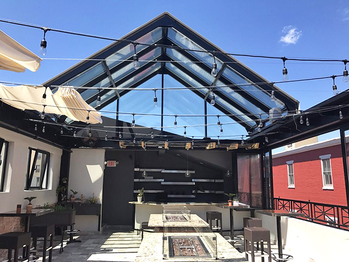 The glass-roofed dining space brings the outdoors in, with string lights creating the perfect ambiance for an evening of culinary delight.