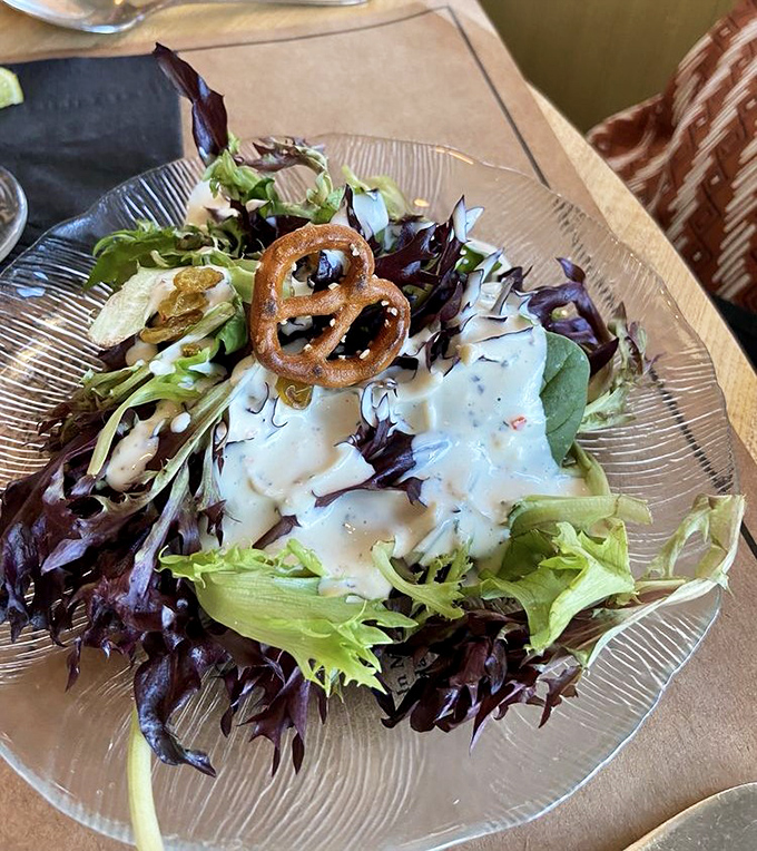 A salad that knows it's not just an opening act. Fresh greens, thoughtful dressing, and is that a pretzel garnish? Playful and sophisticated.