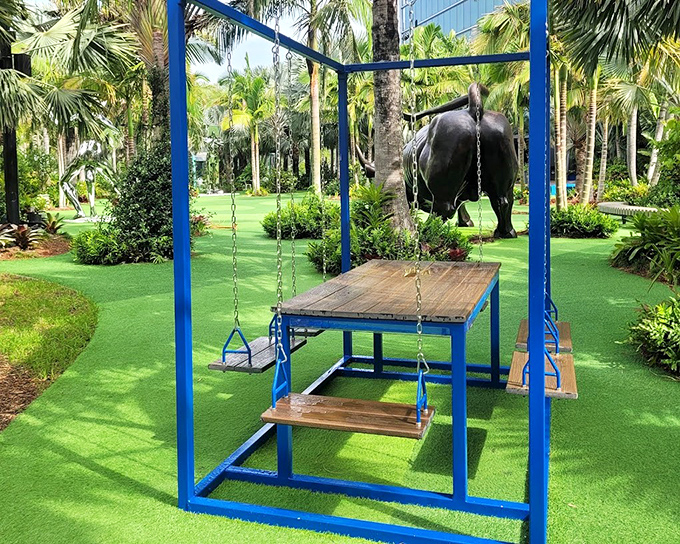 This blue swing table installation isn't just art—it's an invitation to linger, converse, and experience the garden from a playfully different perspective.