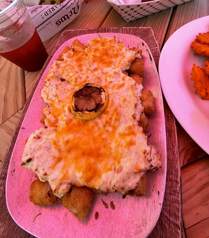 These aren't just any tater tots &ndash; they're golden-brown nuggets of potato perfection topped with melted cheese and a charred lemon for that touch of coastal elegance.