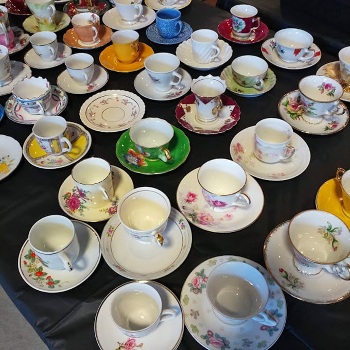 Teacups and saucers arranged like a porcelain rainbow, each one waiting to elevate your morning coffee from mundane to "I'm basically royalty."