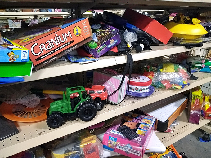 Board games, green tractors, and childhood nostalgia line these shelves. Cranium for $3 beats any digital download for family game night.
