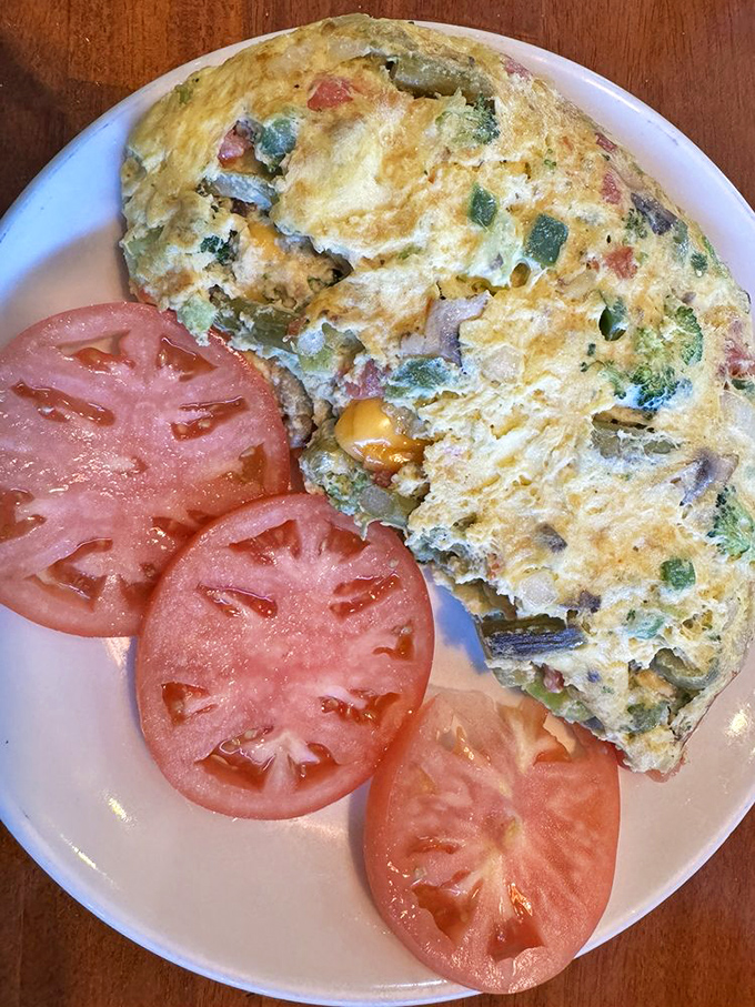 This isn't just any omelet&mdash;it's a vegetable garden wrapped in fluffy egg clouds, with tomato slices providing a juicy counterpoint.