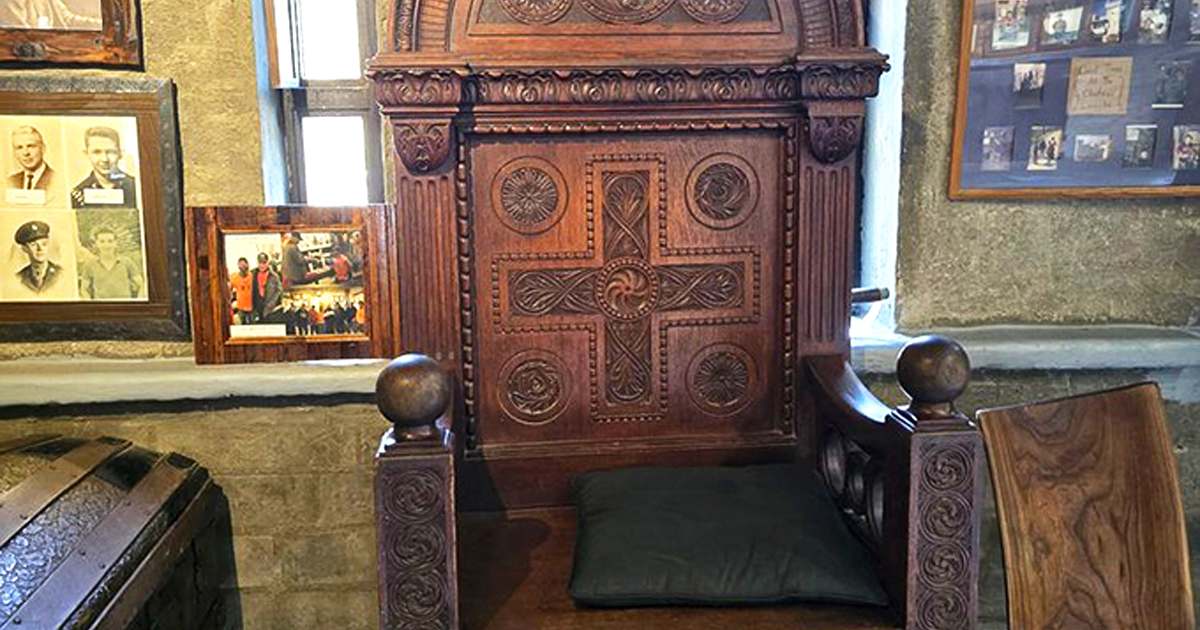 This ornately carved chair with its prominent cross design brings ecclesiastical gravitas to the castle's interior. No ordinary seating arrangement here.
