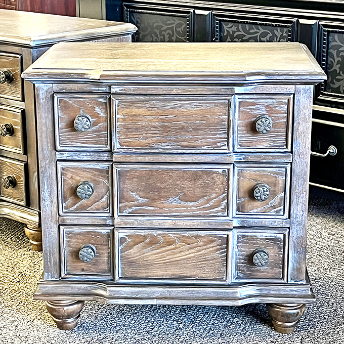 This weathered nightstand tells a story of coastal charm and practical storage—beach house vibes without the oceanfront property taxes.