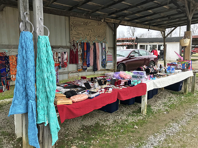 Outdoor vendor tables display handmade crafts and treasures under pavilion roofs where community gathering meets serious bargain hunting.