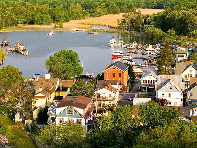 An aerial view of Chesapeake City nestled along the waterfront, where colorful homes and boats dot the landscape around a serene harbor.