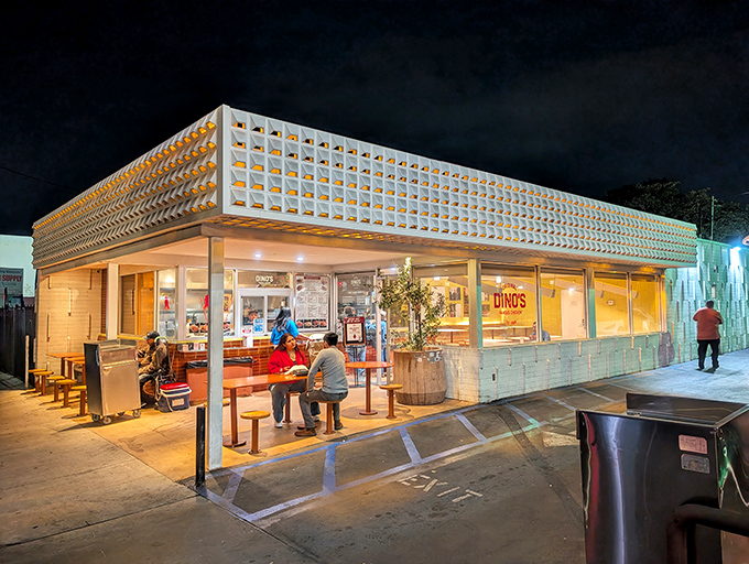 Dino's glowing nighttime storefront beckons hungry diners like a lighthouse guiding ships to delicious, crispy shores.