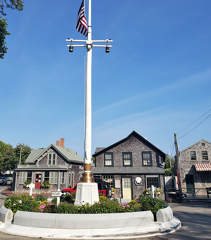 The harbor's iconic flag pole stands sentinel over weathered shingle cottages that define this island's enduring charm and timeless appeal.