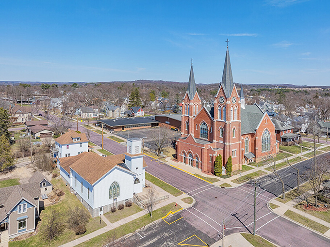 Twin spires pierce Reedsburg's skyline above tree lined streets, marking a peaceful community where faith and affordable retirement intersect beautifully.