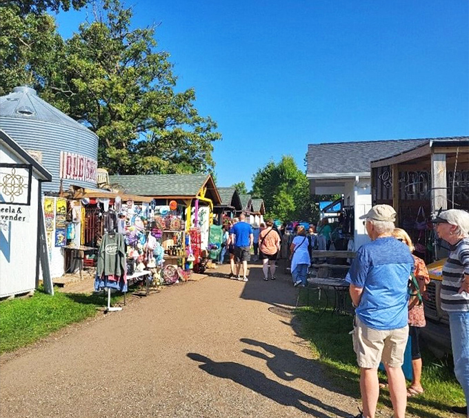 The flea market's bustling main drag, where shoppers hunt for treasures while secretly hoping their spouses don't notice how much they're buying.