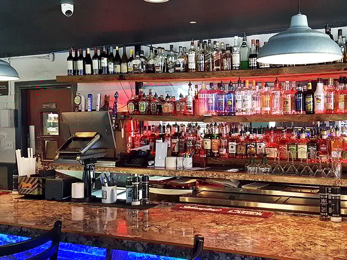 The bar's impressive selection of spirits glows like a beacon of hospitality, promising liquid courage before trying your first gator bite.