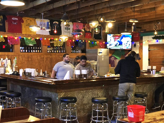 The bar area: where strangers become friends over shared cheese skirt stories and cold Texas beers.