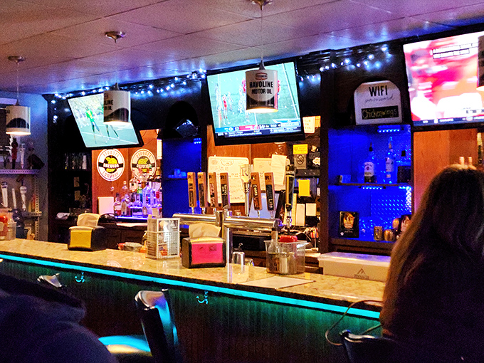 The bar glows with neon promise, where cold drafts and warm conversation flow with equal abundance.