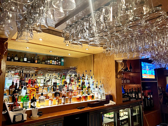 The bar's impressive lineup of spirits promises libations for every palate, with glasses hanging overhead like crystal stalactites.