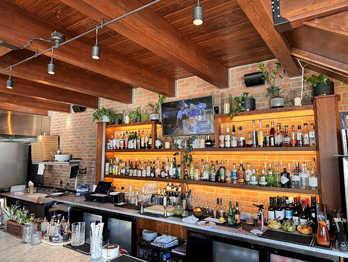 The bar at Cork & Fork doesn't just serve drinks—it showcases them like the liquid treasures they are, backlit to create a warm amber glow.