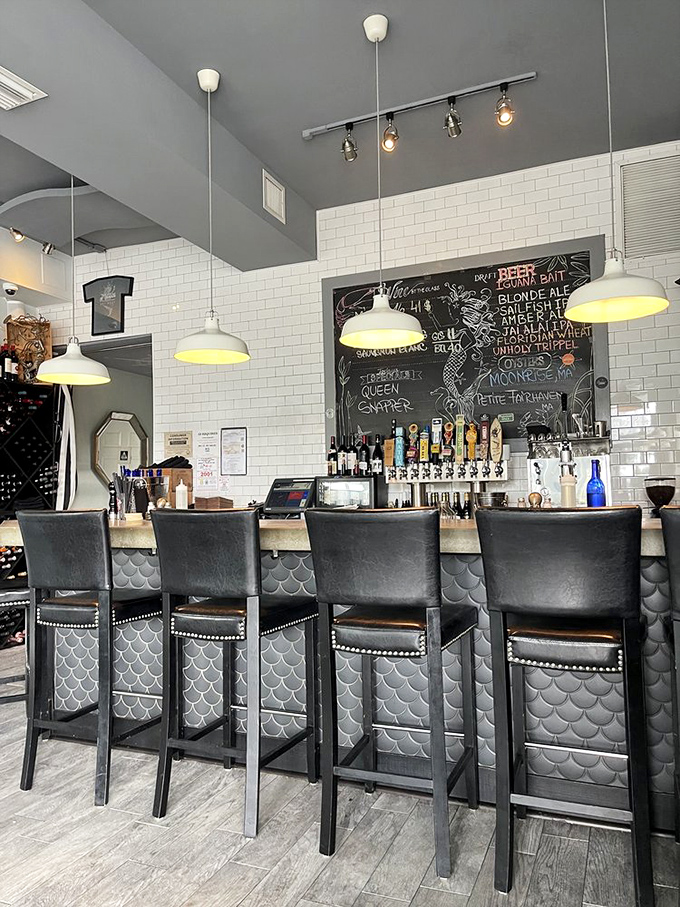 The bar's fish-scale tiles shimmer like a mermaid's tail, while the chalkboard promises liquid treasures from near and far.