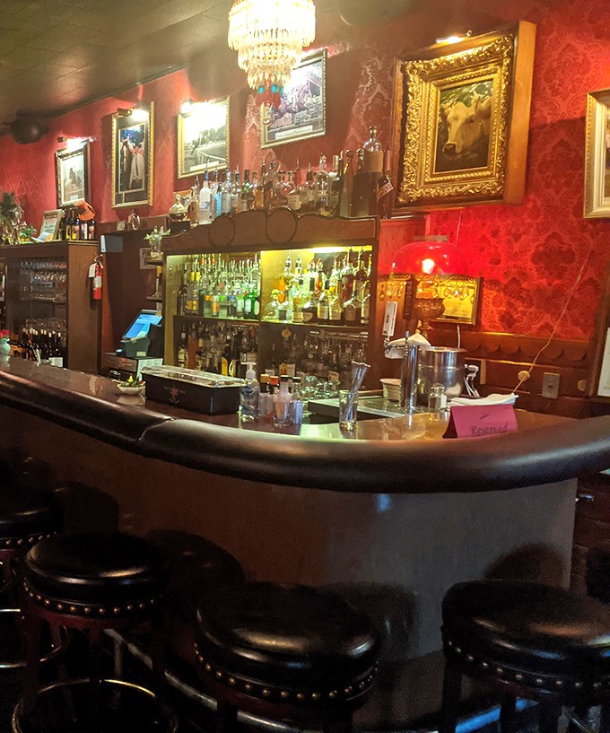 The bar isn't just serving drinks—it's preserving history with every pour, surrounded by gilded frames and crimson walls.