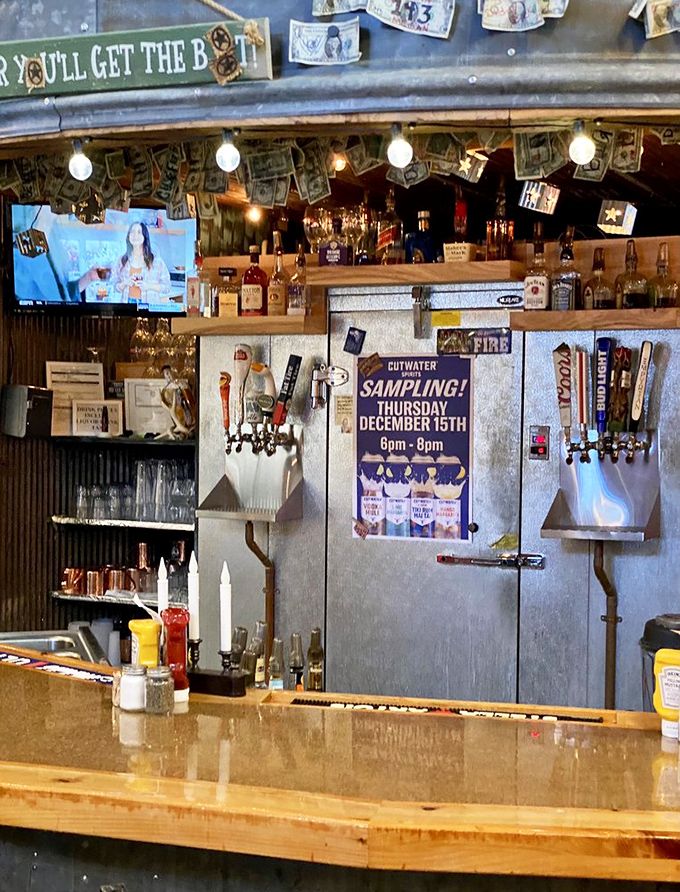The bar area where dollar bills tell stories and the sign hints at the establishment's playful spirit. Be nice or you'll get the boot!