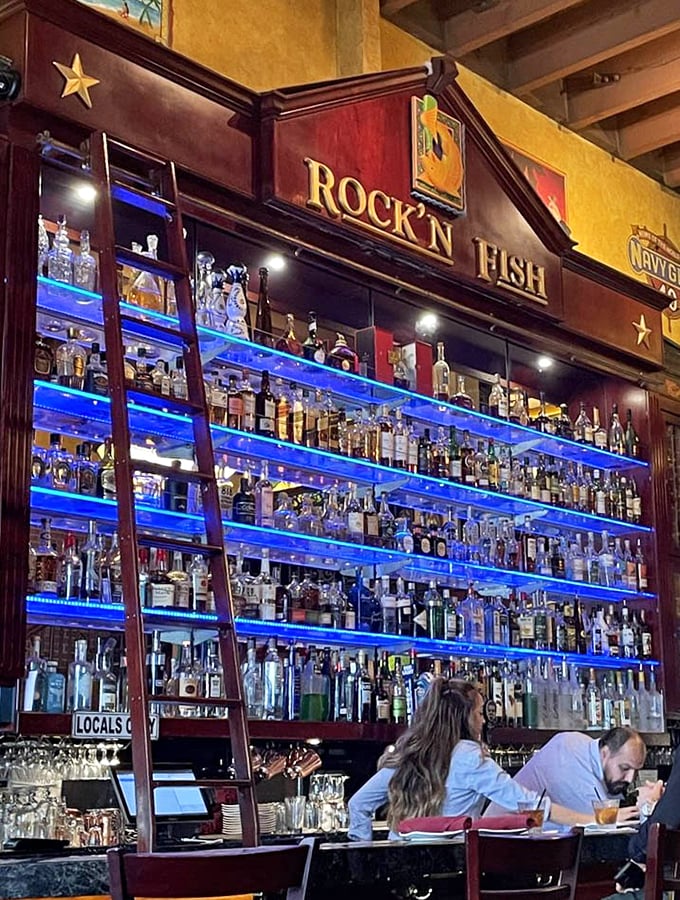 That illuminated bar wall isn't just impressive &ndash; it's a liquid library with enough spirits to weather any storm or celebration.