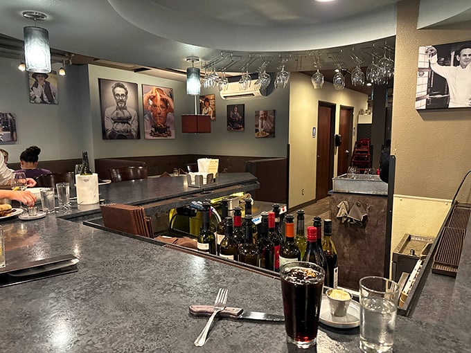 The bar area offers a front-row seat to liquid craftsmanship, where wine bottles stand at attention like soldiers guarding the gateway to a good evening.