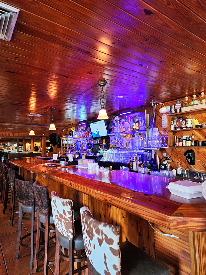 The bar glows with promise under purple lights, where cowhide barstools invite you to saddle up for an evening of libations.
