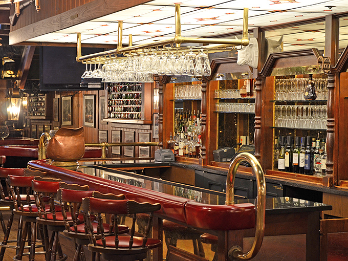 A bar that says "pull up a stool and stay awhile," with gleaming glassware hanging like crystal stalactites ready to catch your favorite spirit.
