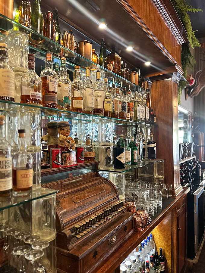 The bar's glass shelves showcase bottles like museum pieces, while the vintage cash register reminds us that some traditions are worth preserving, especially when they involve bourbon.
