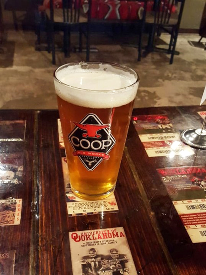 A perfectly poured local beer sits atop a table that's seen thousands of barbecue triumphs, ready to cut through the richness of smoked perfection.