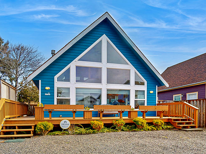 The Blue Wave Cottage stands like a sapphire against the coastal landscape, its massive windows practically begging to frame your sunset Instagram shots.