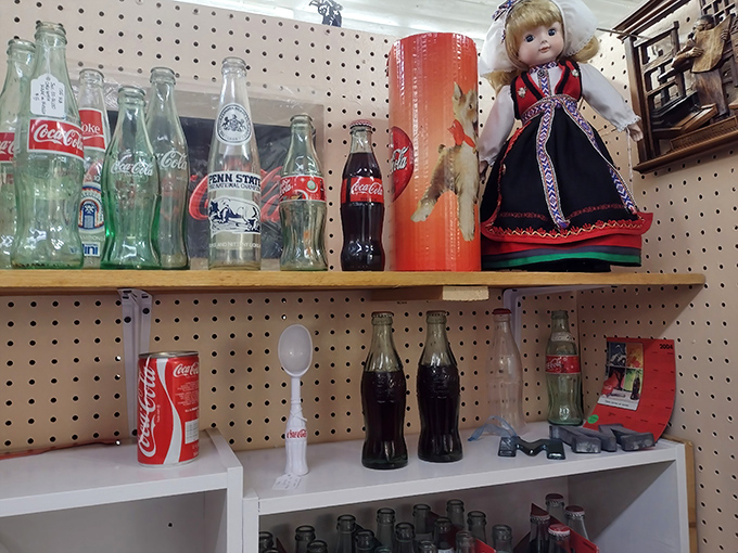 Vintage Coca-Cola bottles and a traditional doll create the perfect still life of Americana.