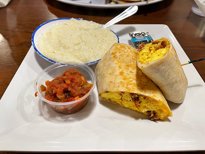 A breakfast burrito that's ready for its close-up, with a side of grits and salsa that means business. Morning wrapped in a tortilla.